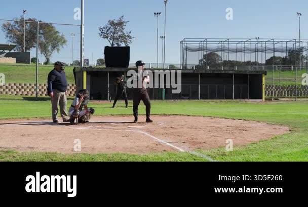 Asian male batter swinging, missing at home plate after pitcher winding ...