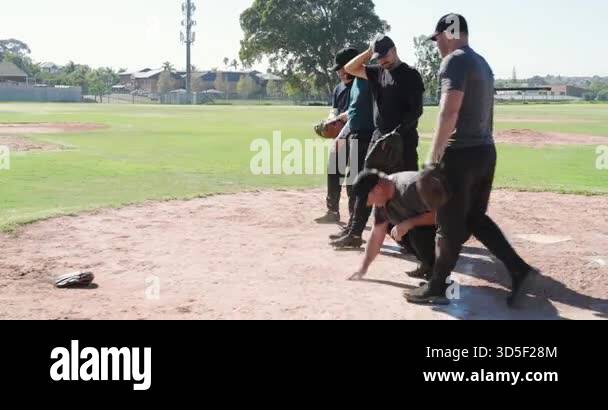 Male teammates adjusting gloves, grabbing helmet, tapping backs and ...