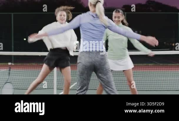 Performing arm circles, diverse female teammates warming up for tennis ...