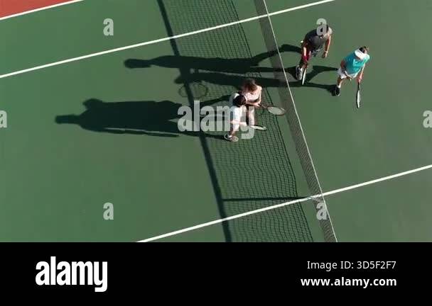 Diverse tennis teammates stepping to net as match ends tapping rackets ...