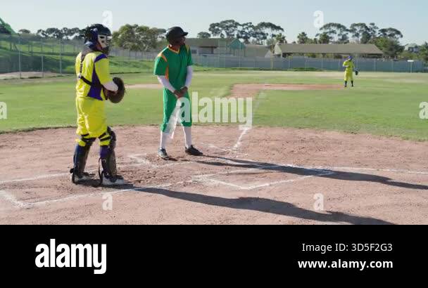 Pitcher delivering ball, African American man swinging bat, missing ...