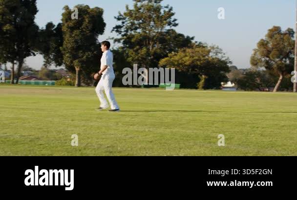 Reacting to coach signal male cricket teammates jogging, picking up ...