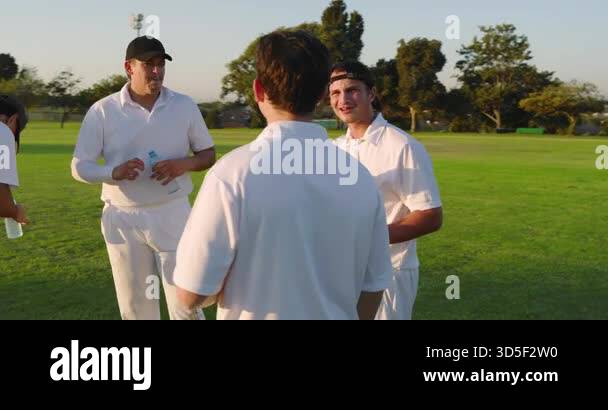 Thirst driving Diverse male cricket teammates drinking water bottles ...
