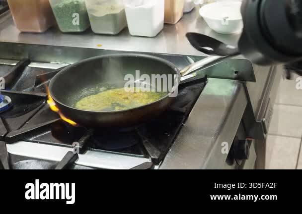 Professional chef preparing authentic indian cuisine in sizzling frying ...