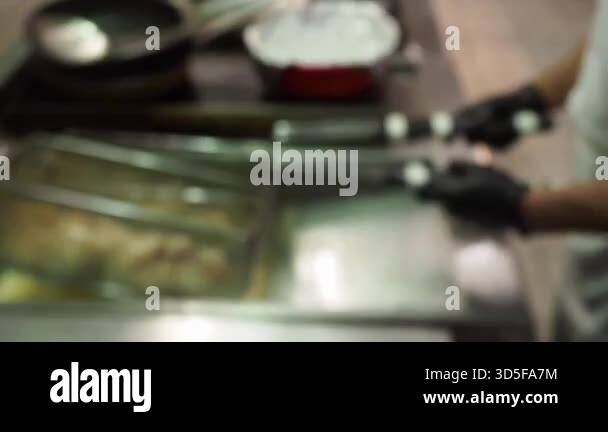 Skilled chef carefully frying golden brown samosas in bubbling hot oil ...