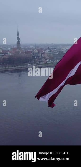 Drone View Of Riga Old Town With Latvian Flag Waving In Foreground ...