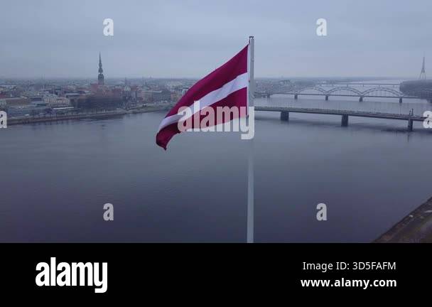 Drone View Of Riga Old Town With Latvian Flag Waving In Foreground ...