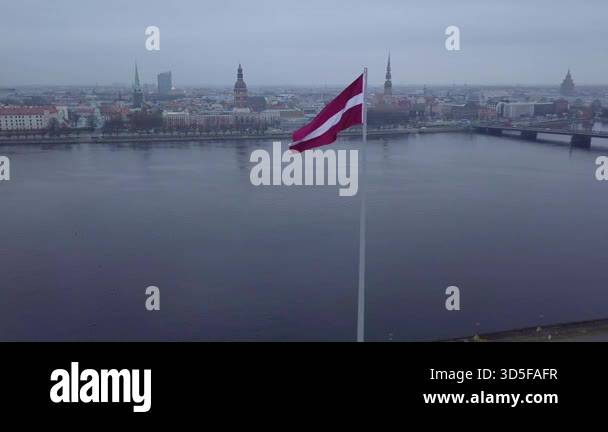 Drone View Of Riga Old Town With Latvian Flag Waving In Foreground ...