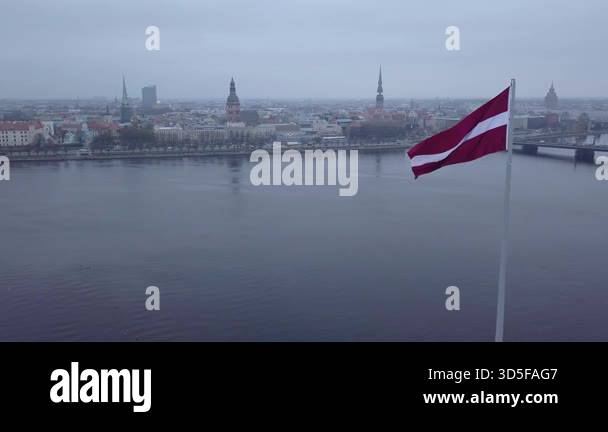 Drone View Of Riga Old Town With Latvian Flag Waving In Foreground ...