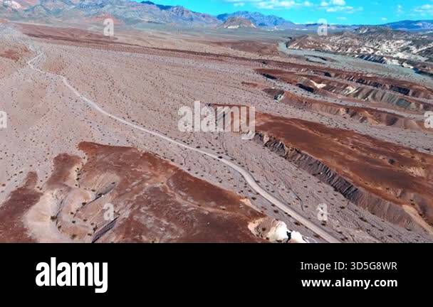 Approaching a road crossing the vast desert covered with shrubs. Aerial ...