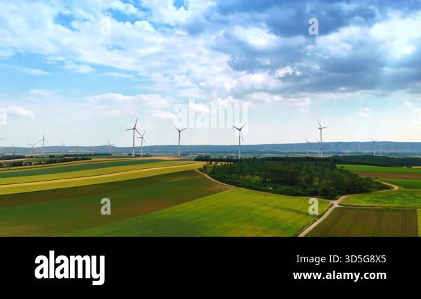 Lots of wind turbines rotate in the vast field in summer. Drone footage ...