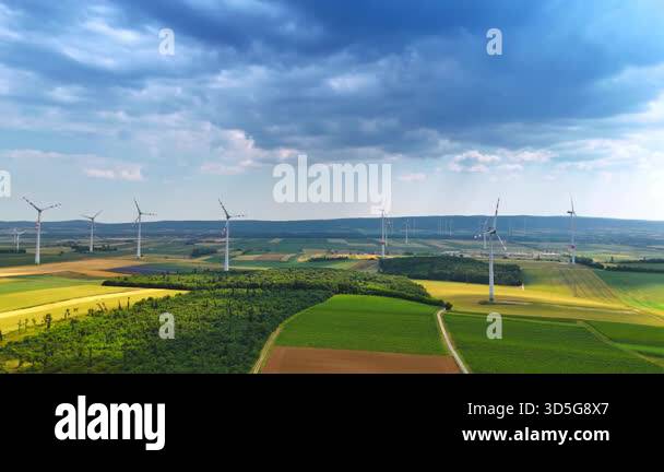 Striking green summer fields with wind farms. Drone flight over the ...