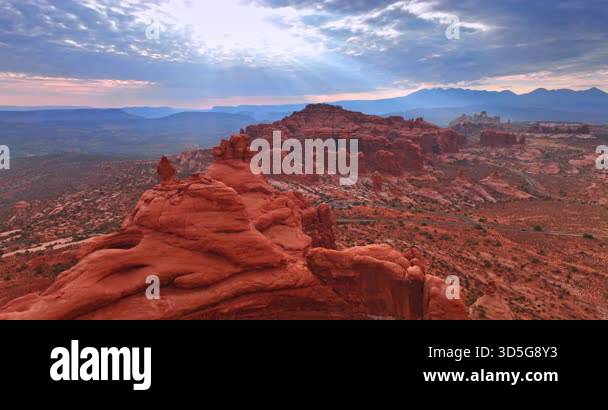 Orange rocks of whimsical shape in the deserted area. Beams of setting ...