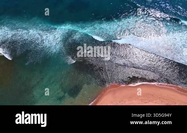 Turquoise waterscape with white foamy waves rolling to the shore ...