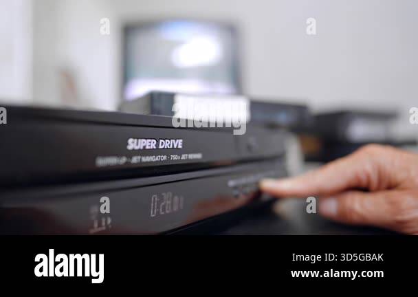 Caucasian male hand presses the button on the panel of VHS player ...
