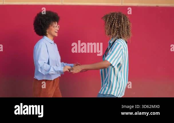 Two friends dance joyfully on a vibrant city street, illustrating a ...