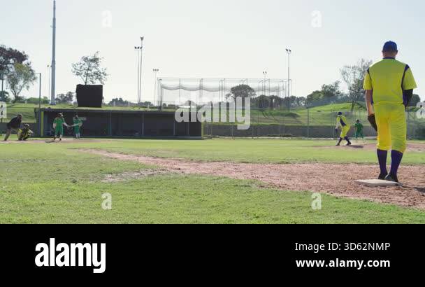 Batter connecting with pitch, pitcher in yellow uniform chasing ...