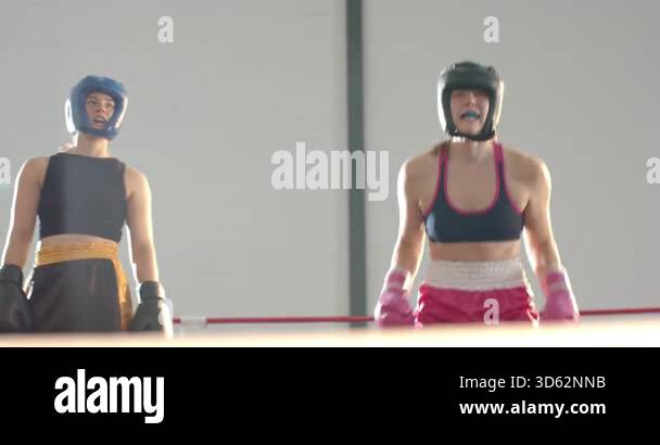 After pausing in ring, female boxer in pink jumping in celebration with ...