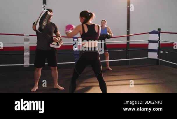 At coach prompt female boxer throwing jab cross hook combo at focus ...