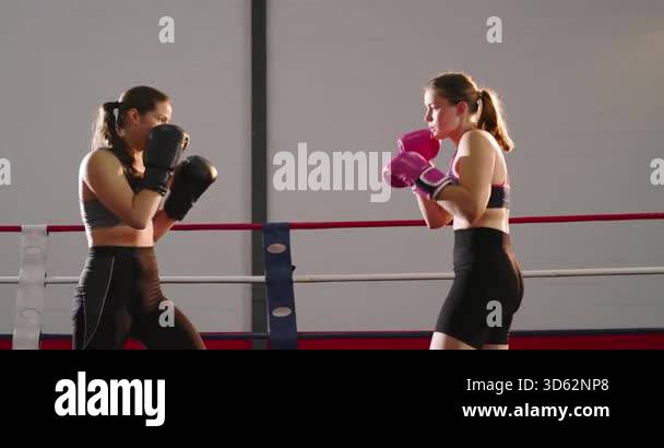 Female trainees sparring with boxing gloves jabbing until coach ...