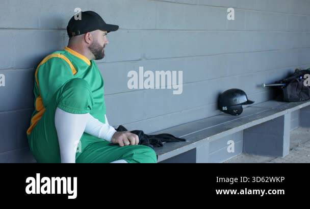 Diverse male players welcoming teammate entering dugout with baseball ...