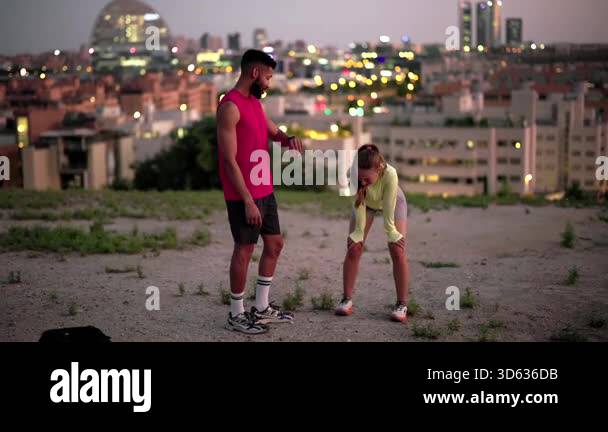 Professional personal trainer motivating a tired female runner who is ...