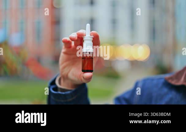 Hand holds nasal spray, offering quick relief for common cold symptoms ...