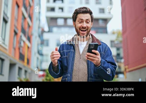 Individual radiates happiness and triumph while engaging with mobile ...
