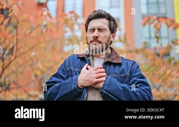 Individual experiencing sudden chest pain distress outdoors. Hands ...