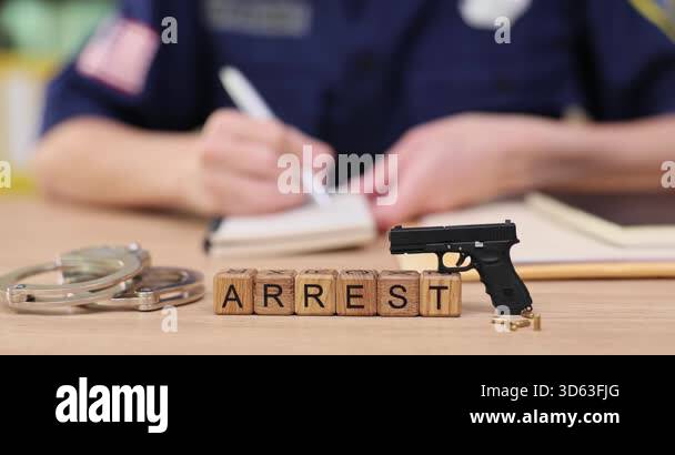 In a quiet police station, an officer sits at a desk. The officer ...