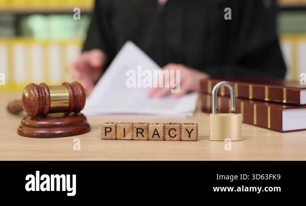A judge reviews legal documents on piracy while gavel and locks are ...