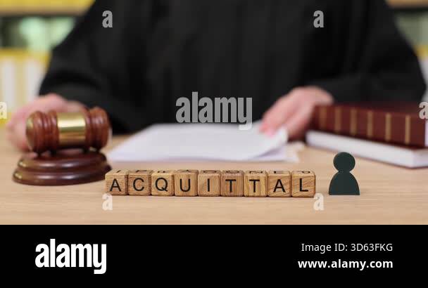 In a courtroom, a judge delivers a crucial verdict of acquittal. The ...