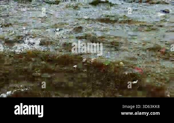 High contrast high angle wide shot of ocean waves with floating trash ...