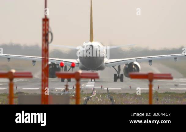 Rear view of a commercial jet airliner positioned on the runway, tail ...