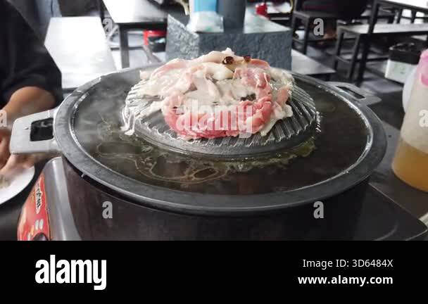 Close-up of Thai-style barbecue grill pan, known as Moo Kratha, with ...