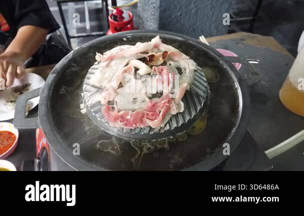 Close-up of Thai-style barbecue grill pan, known as Moo Kratha, with ...