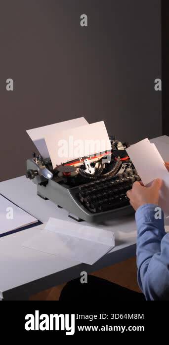 Vertical video person is inserting a blank sheet of paper into an old ...