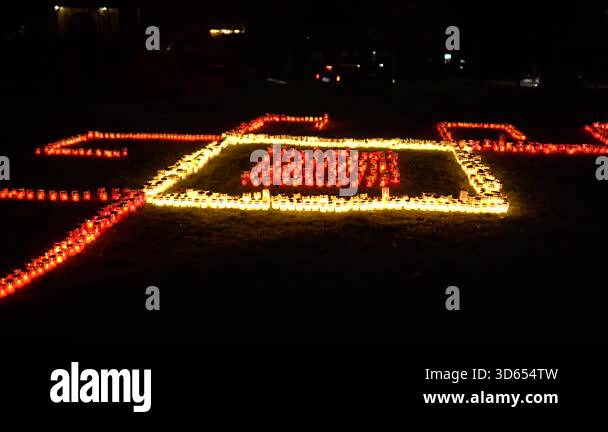 Illuminated candles create stunning patterns on grass, enhancing the ...