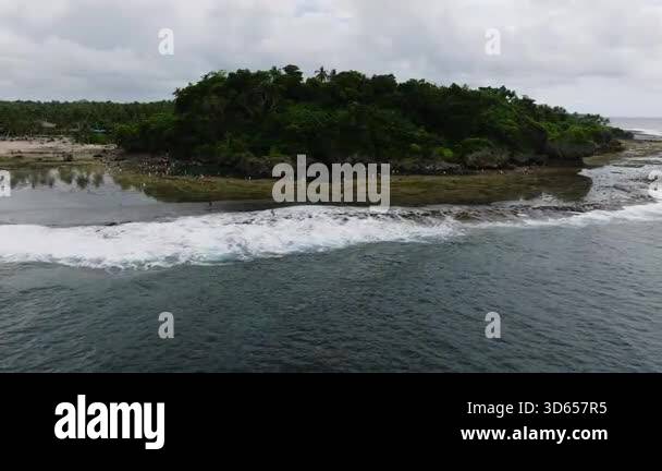 A natural lagoon enclosed by reef formations with people swimming in ...