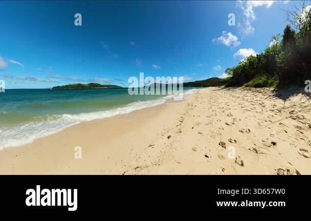 Turquoise sea water and waves crashing over the white sand beach in Bon ...