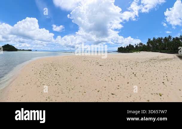 Expansive sandy beach with scattered rocks leading to calm sea in ...