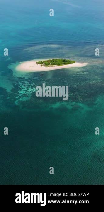 Remote island with sandy beach surrounded by turquoise water and coral ...