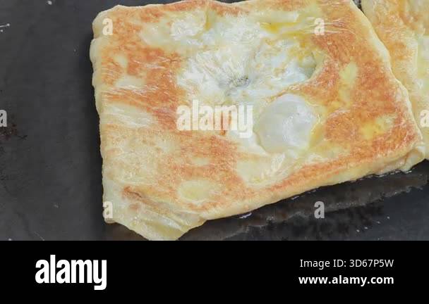 Hot yellow roti cooking on a pan with steam rising, delicious street ...