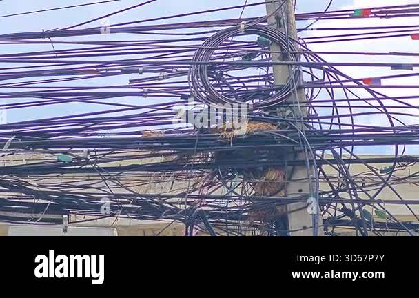 tangled electric and communication cables stretches across the poles in ...