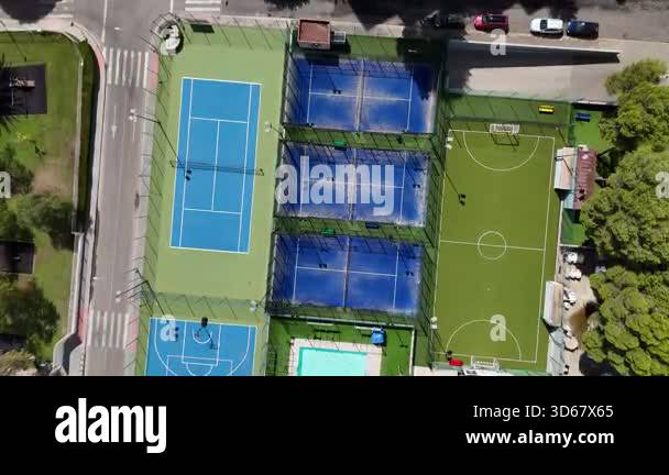 Drone footage showing a modern outdoor sports complex with tennis and ...