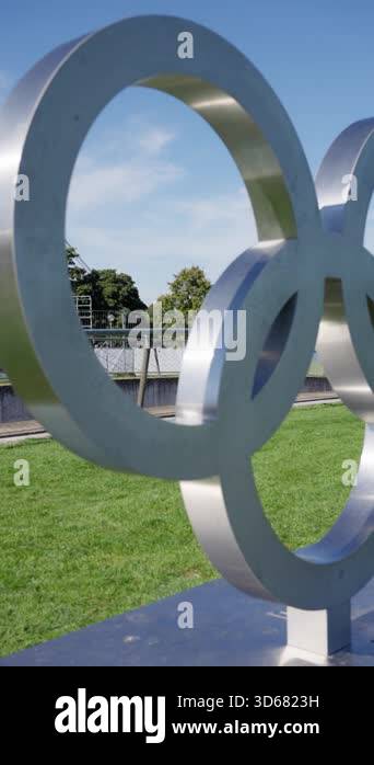 A striking sculpture of the iconic Olympic rings stands against a blue ...