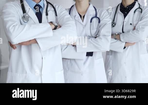 Doctors team standing with arms crossed, wearing white uniforms and ...