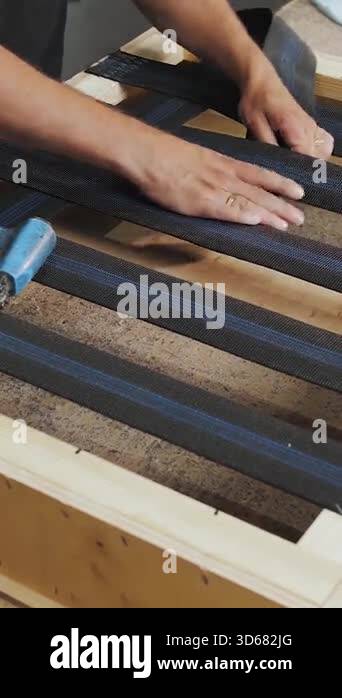 Vertical video. Worker making armchair or soft sofa at furniture ...
