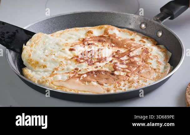 cook remove freshly baked crepe from hot frying pan with spatula in ...