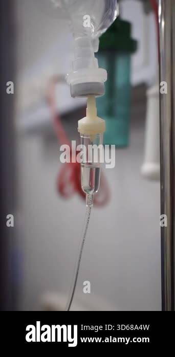 Close-up of an IV drip chamber with fluid dripping steadily in a ...